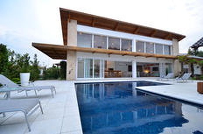 Projeto em terreno lateral gera área de convívio para casa litorânea ...